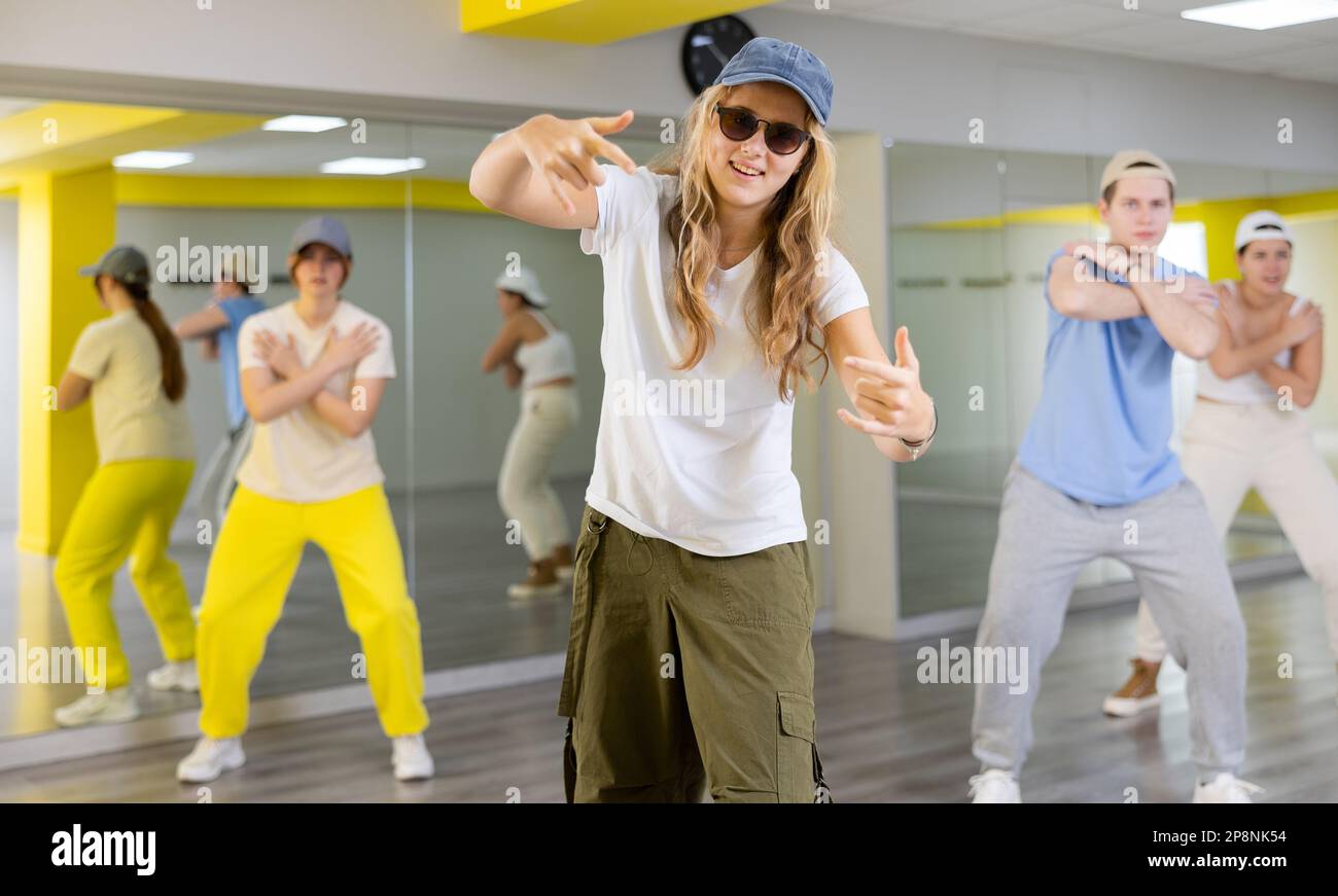Group of young confident teenagers in casual clothes dancing together ...