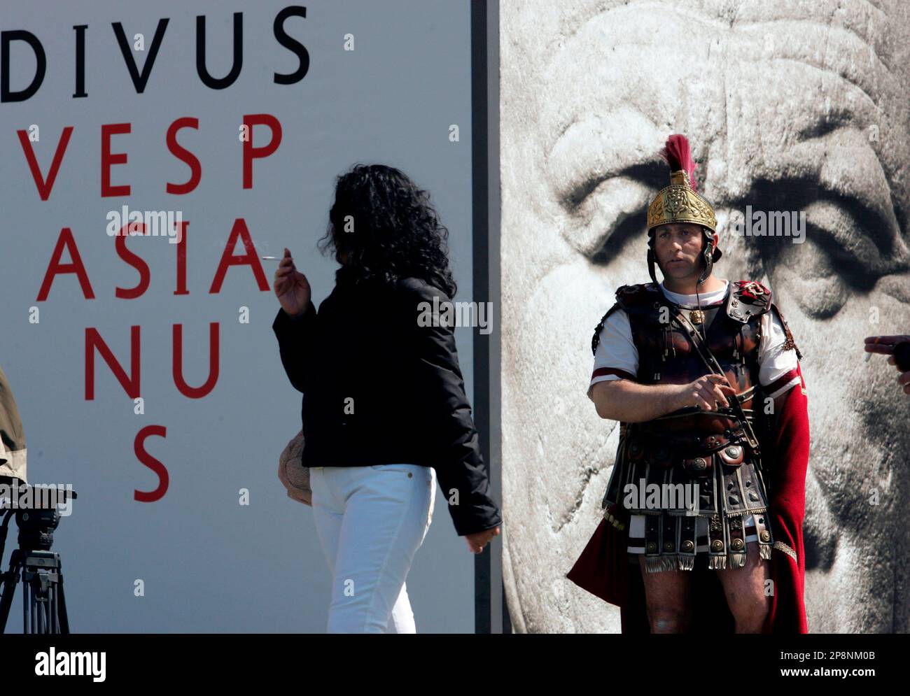 A man dressed as an ancient centurion speaks to a passerby in front of ...