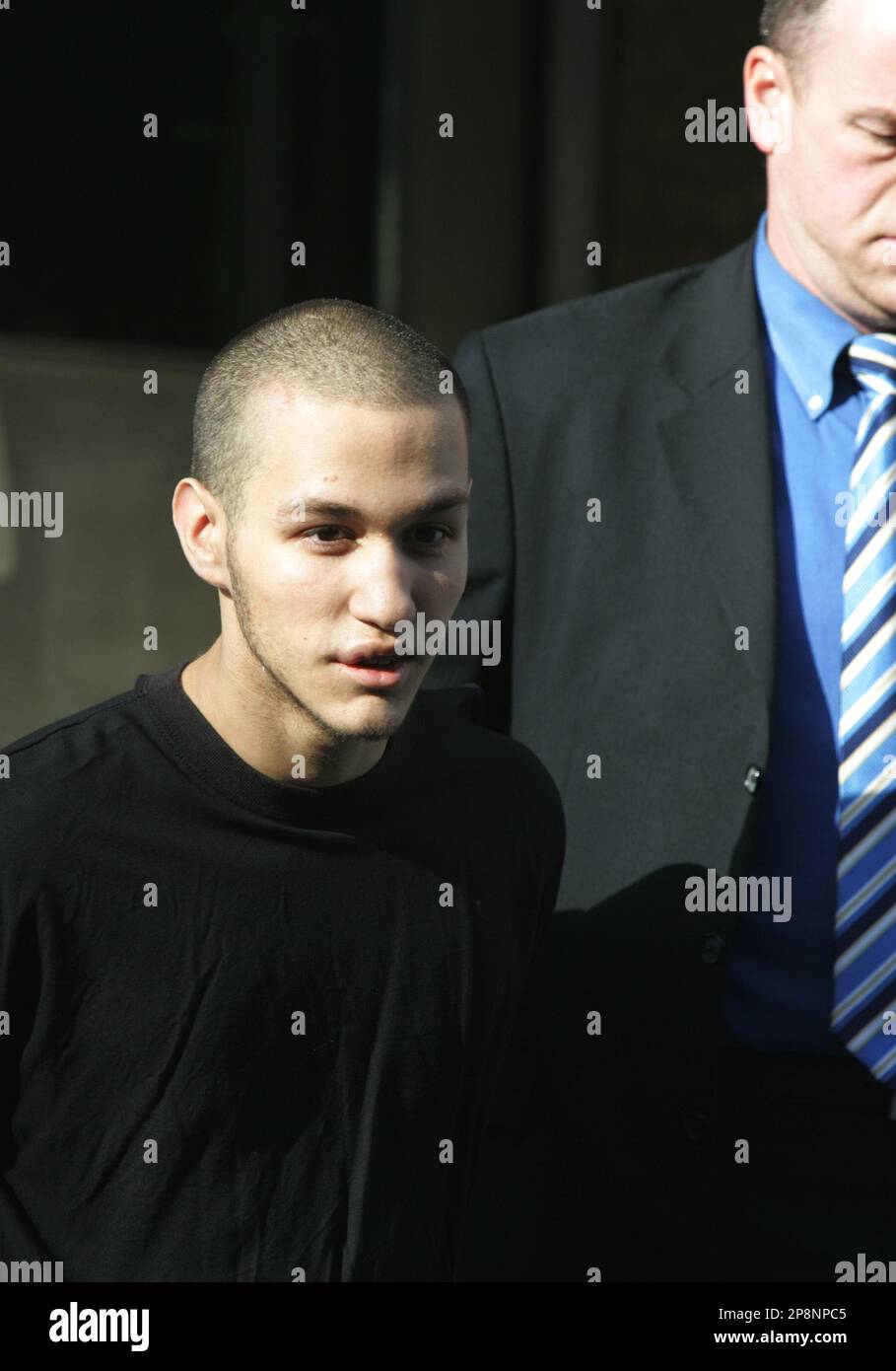 John Katehis, 16, left, is led out of the 76th Precinct police station ...