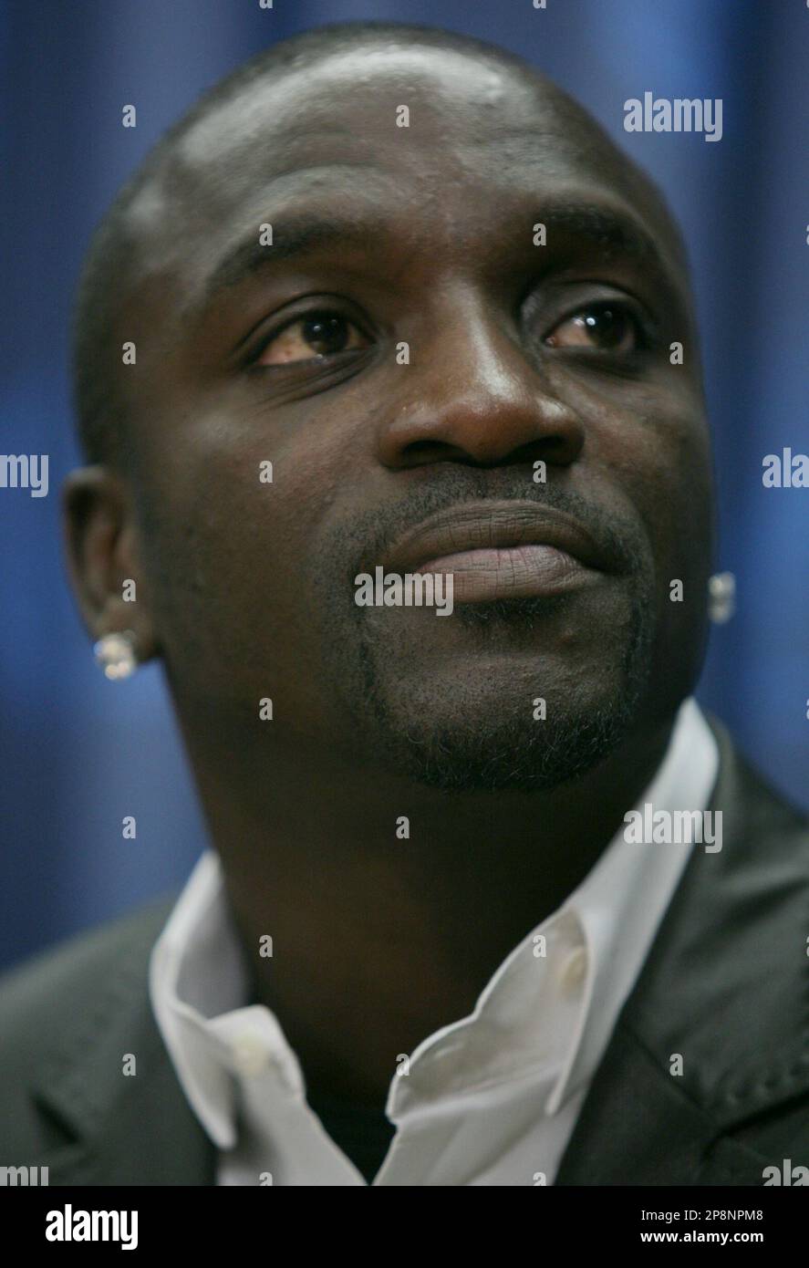 Singer Akon listens during a news conference at the United Nations ...