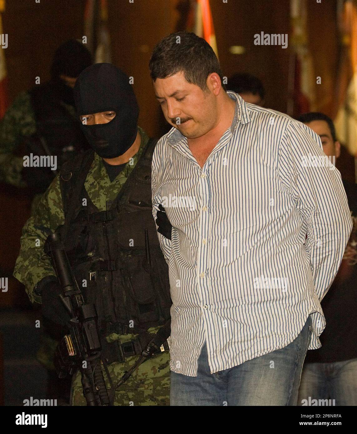 A soldier escorts alleged Mexican drug cartel lieutenant Hector Huerta ...