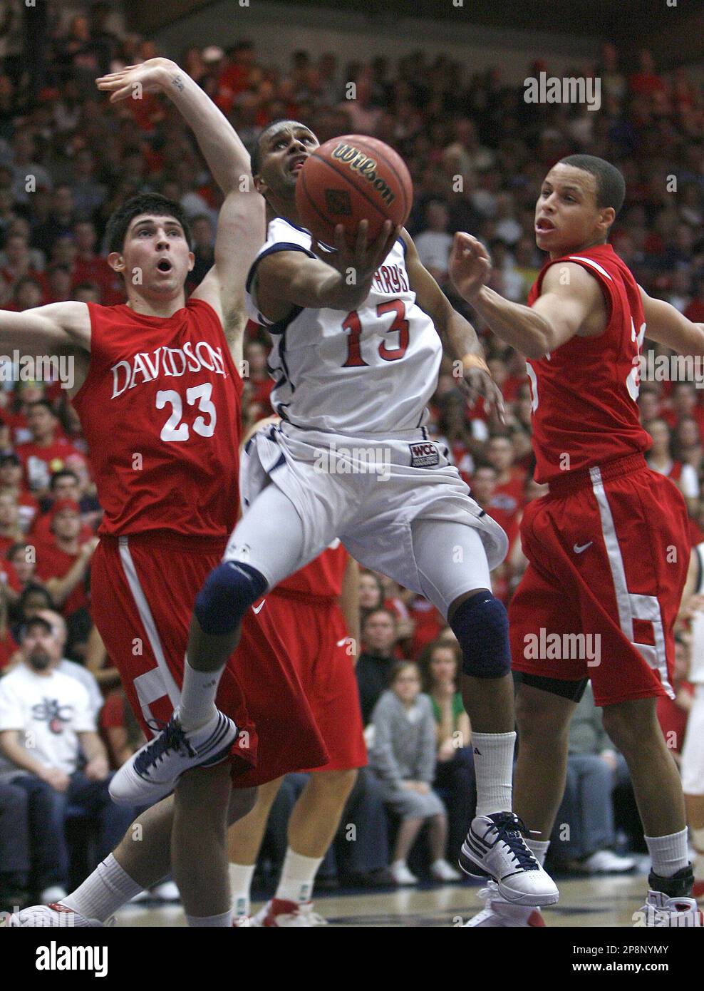 St. Mary's guard Patrick Mills, center, takes a shot over Davidson ...