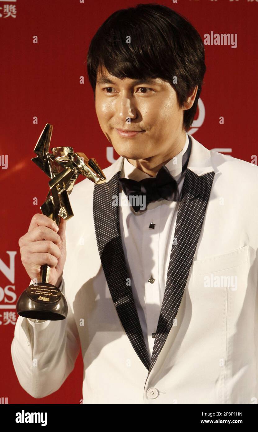 South Korean actor Jung Woo-sung celebrates with the trophy after ...