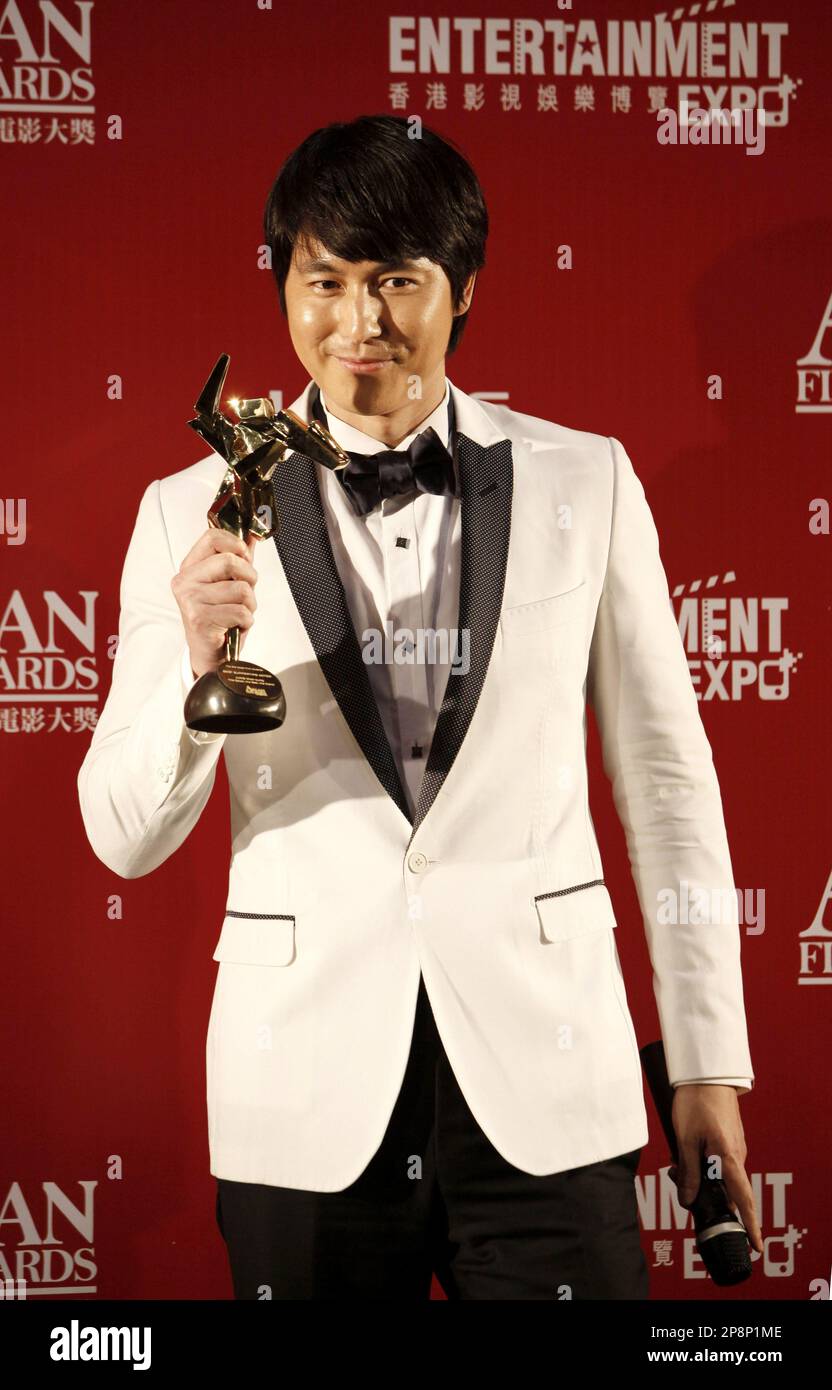 South Korean actor Jung Woo-sung celebrates with the trophy after ...