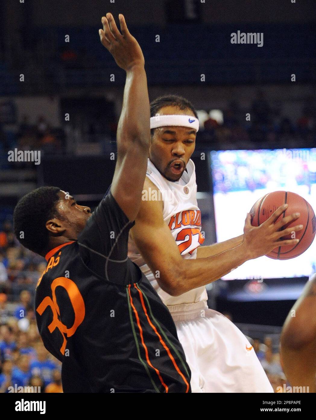 Florida's Alex Tyus (23) gets blocked by Miami's Adrian Thomas (30) in ...