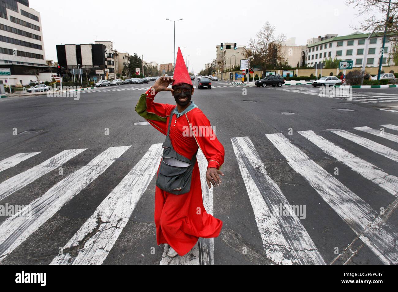 An Iranian man, wearing red robes and making up in black, as a symbol ...