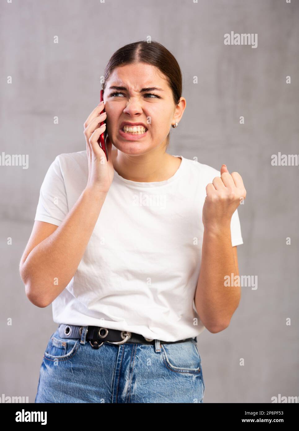 Angry young woman talking on mobile phone Stock Photo - Alamy