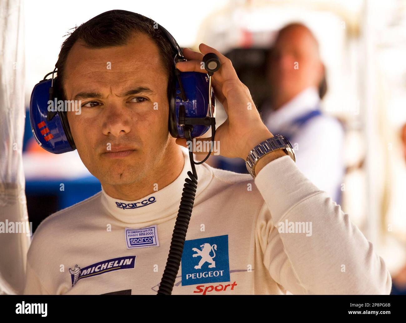 Team Peugeot driver Stephane Sarrazin, of France, listens to a headset ...
