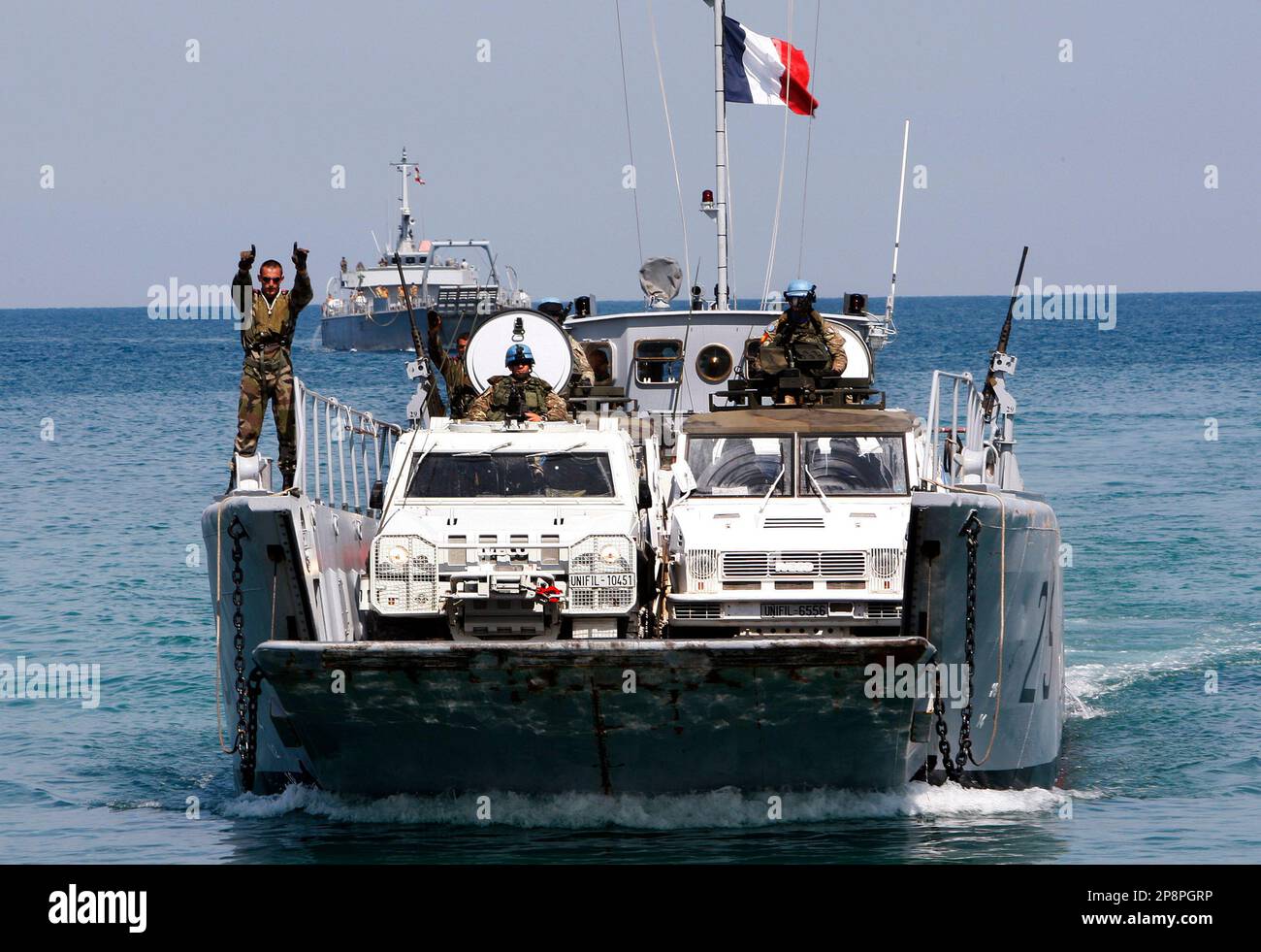 A French soldier, gives directions on a French landing craft which is ...