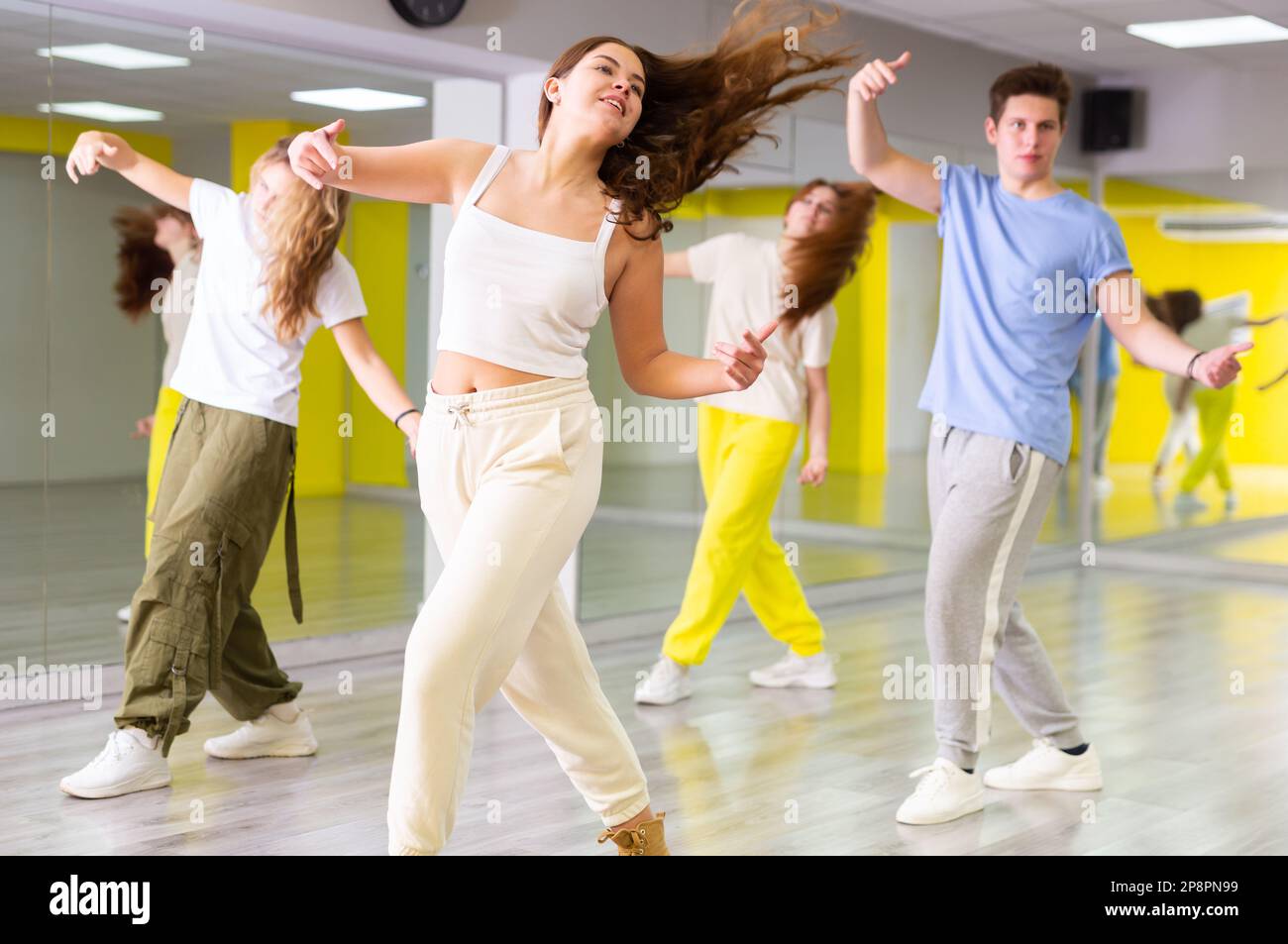 Happy heenagers in dance hall studying new movements, smiling and ...