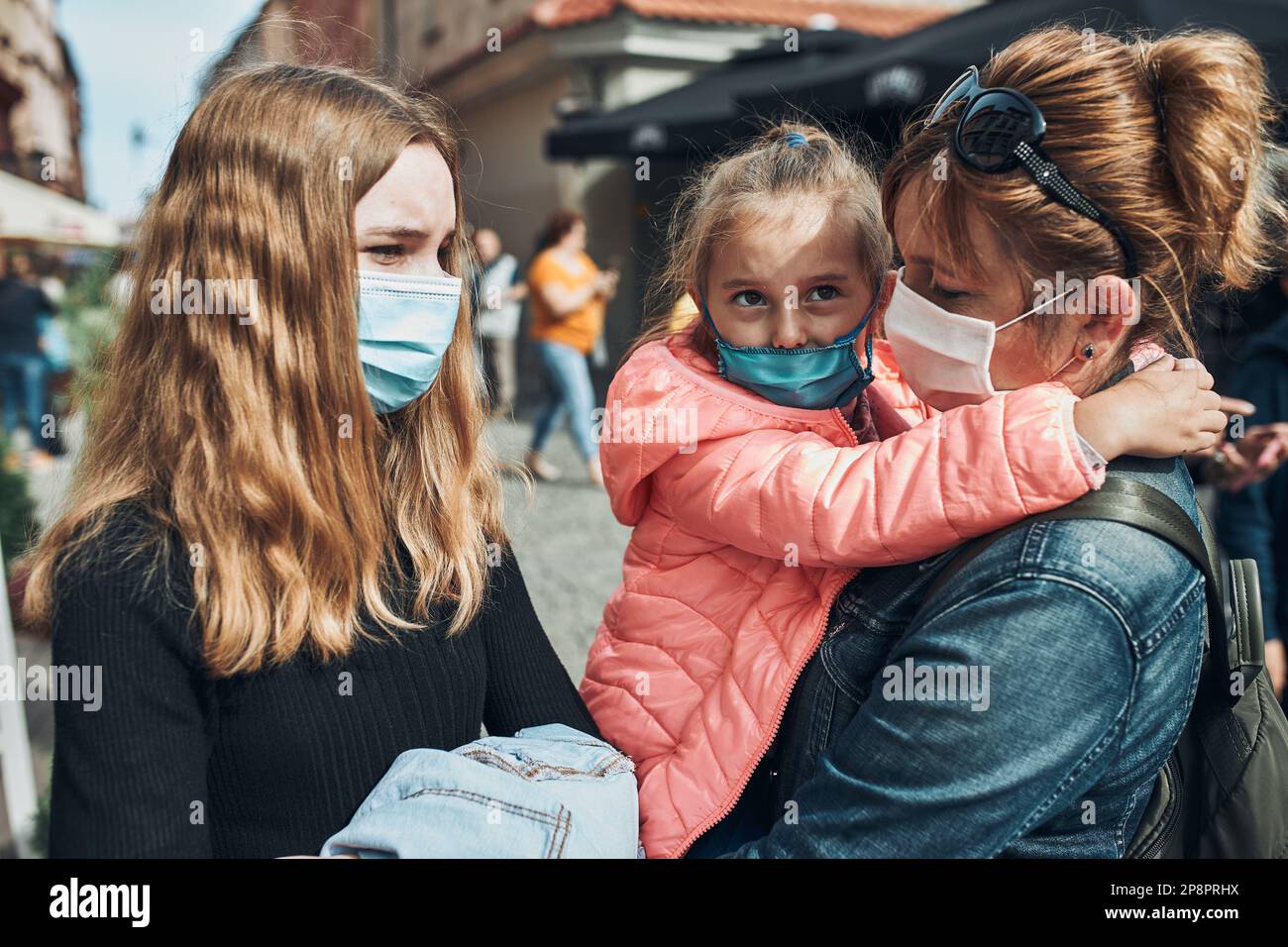 Family mother and her daughters standing in a street downtown wearing ...