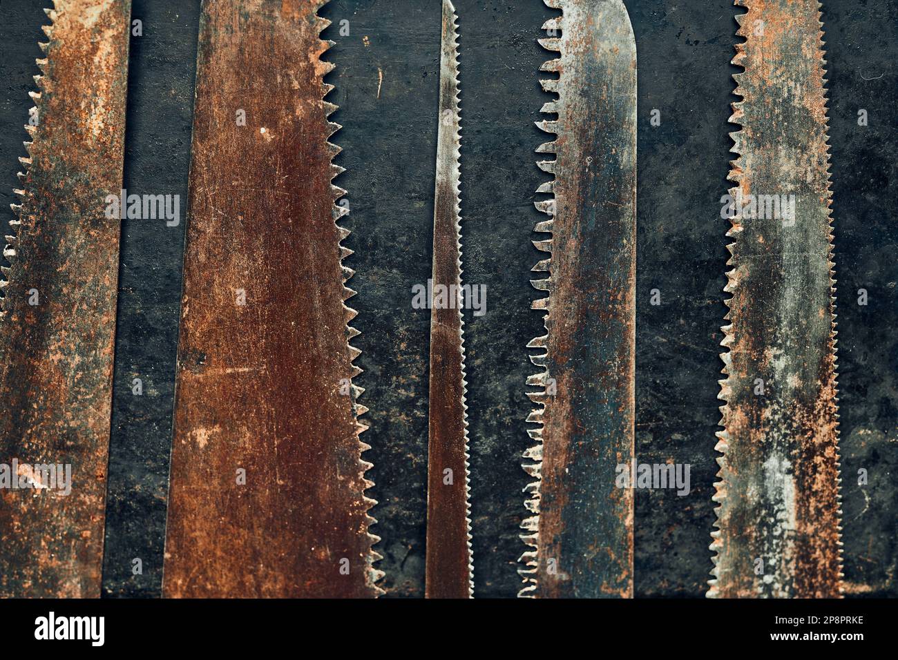 Saws on metal surface. Rusty tools for maintenance. Hardware to fix. Technical background with ...