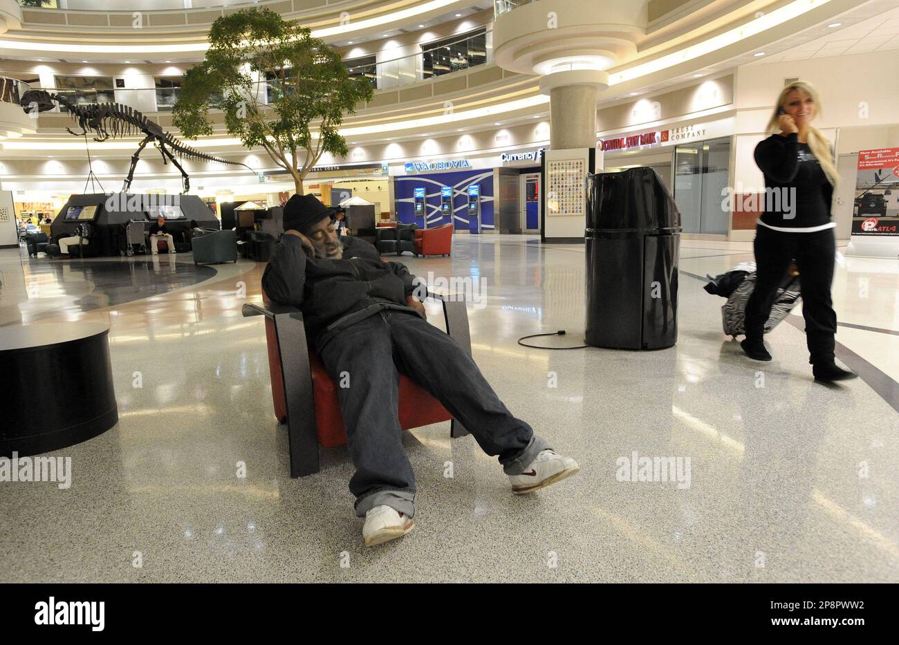 A homeless man naps inside the main terminal atrium of Hartsfield ...