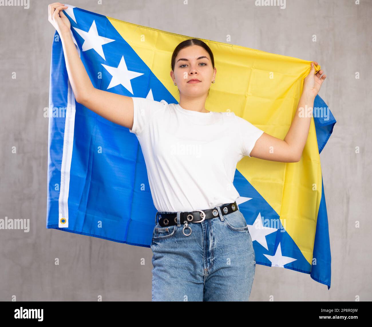 Calm girl stands with Bosnian flag. Isolated on gray background Stock Photo - Alamy