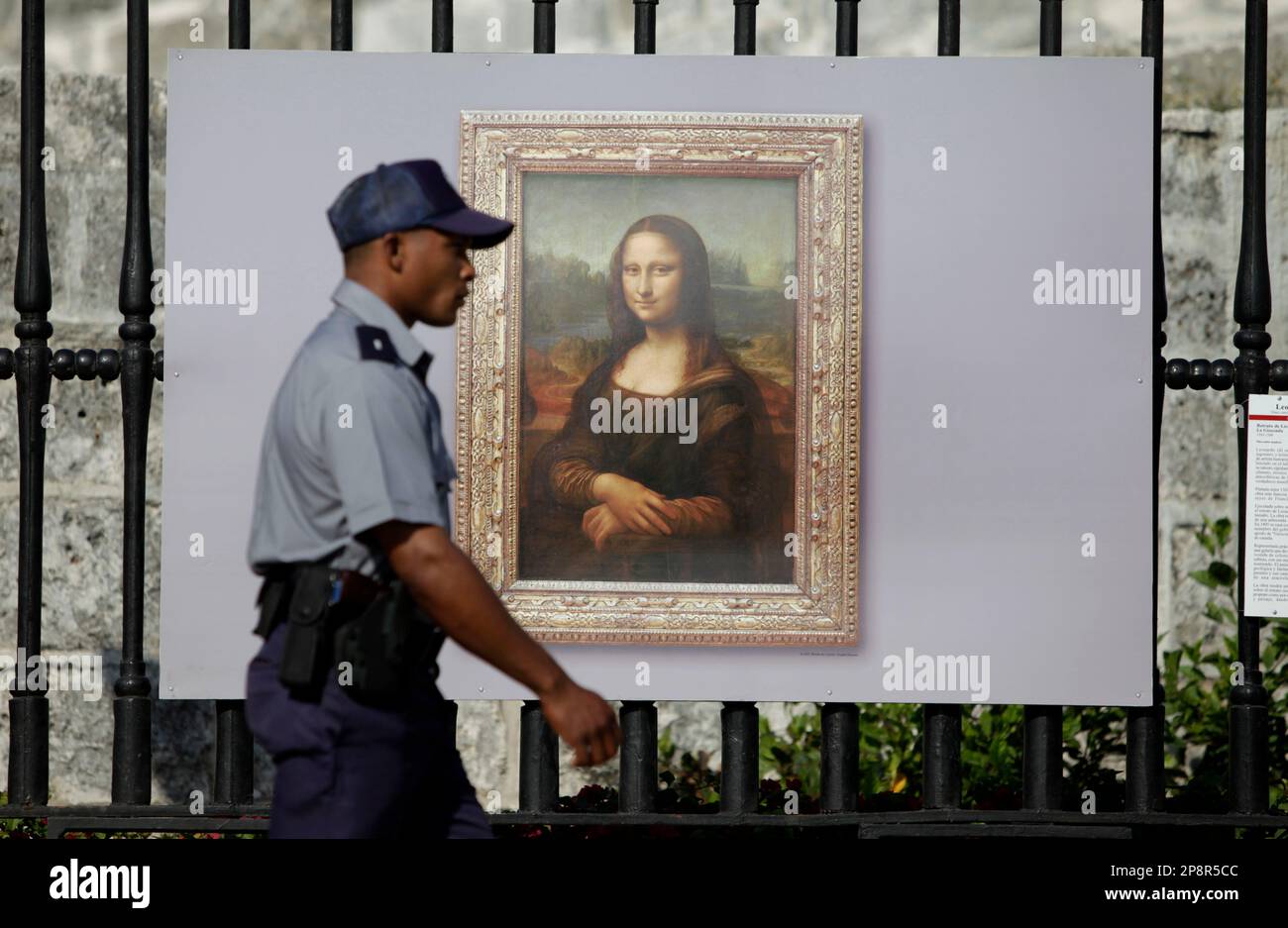 A police officer walks past a photographic reproduction of the "Mona ...