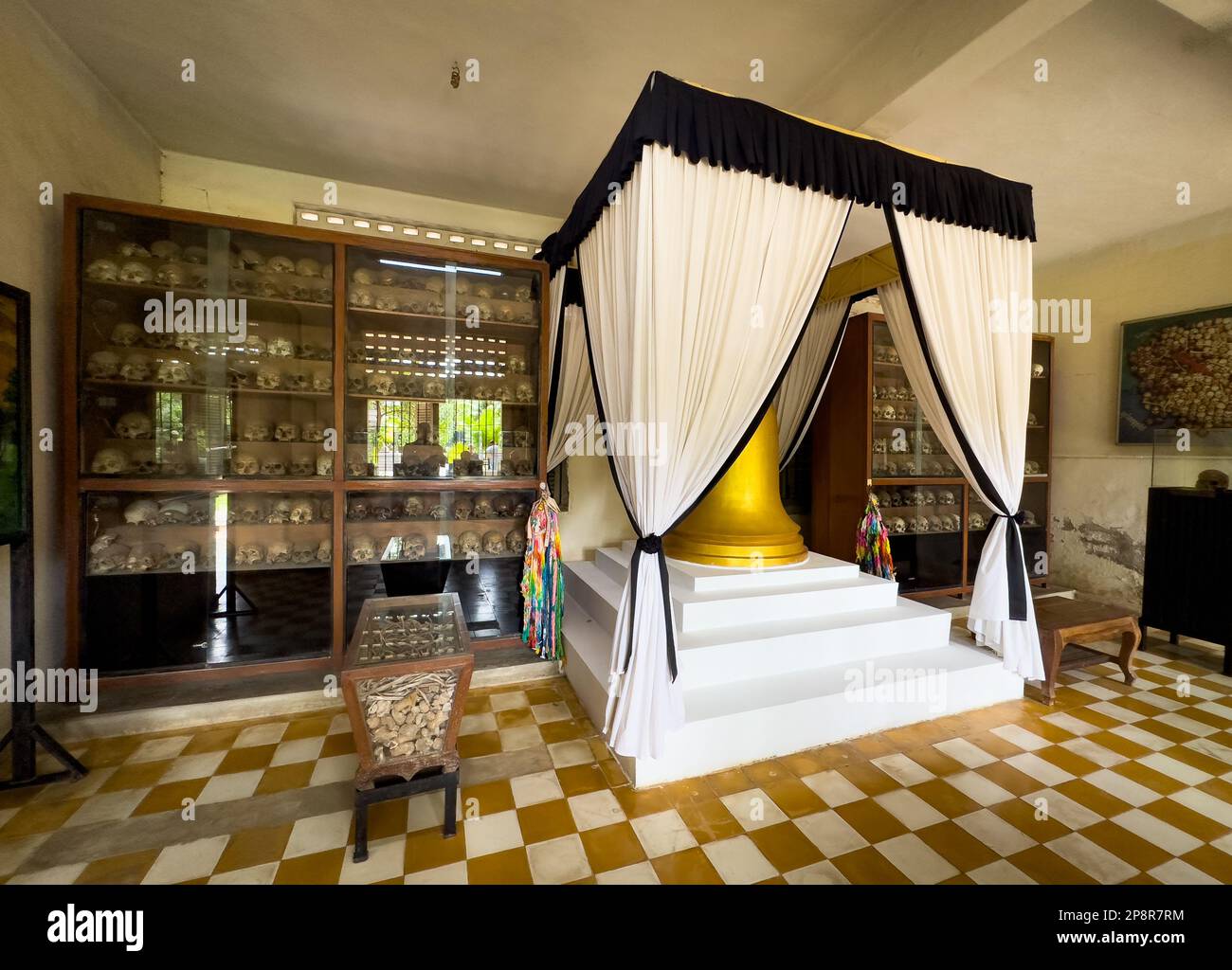 A memorial stupa inbetween cabinets full of skulls of Khmer Rouge ...