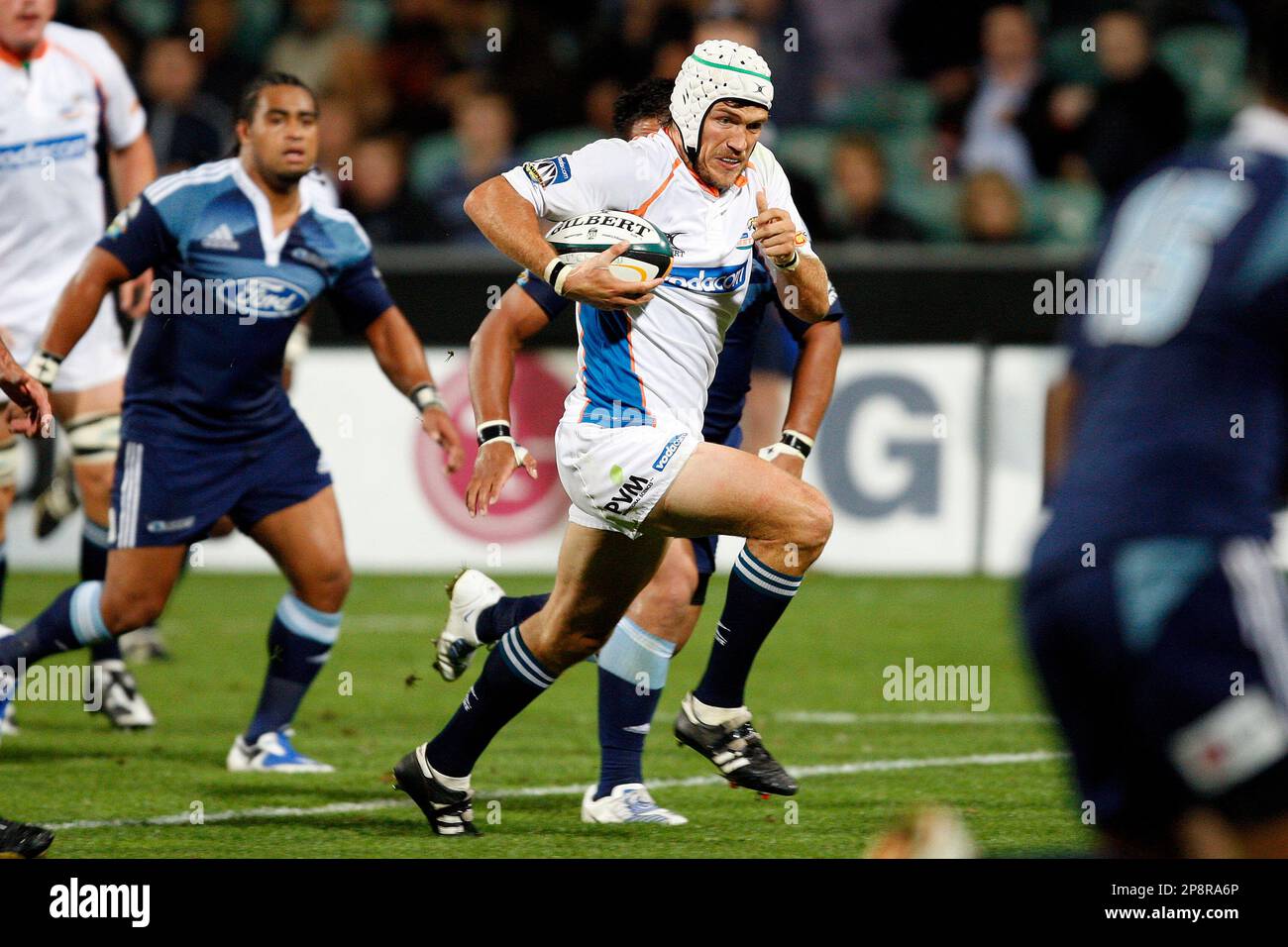 South African Cheetahs' Corne Uys, center, makes a break against the ...