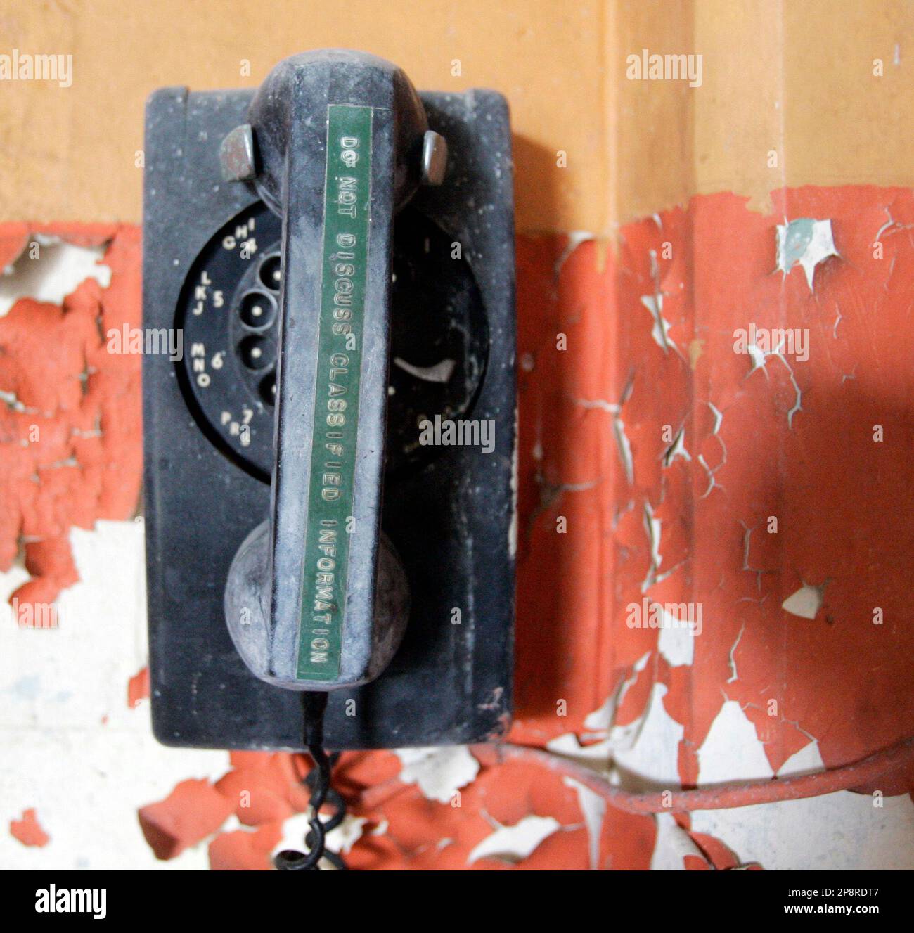 A phone that hangs on the wall reads: 'Do Not Discuss Classified ...