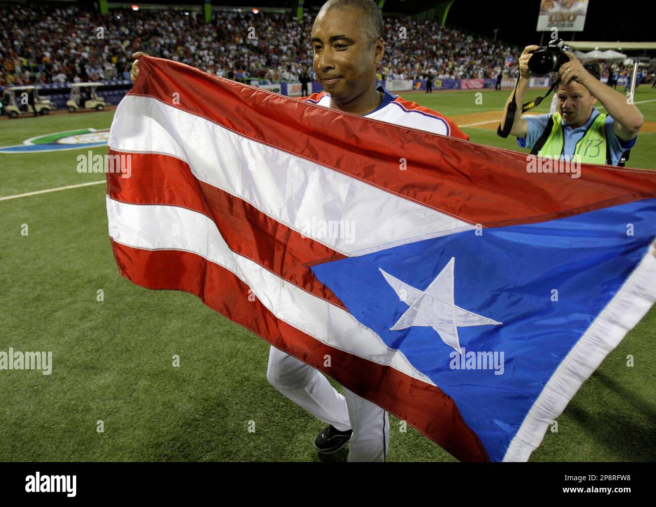 Puerto Rico's Bernie Williams waves his country's flag at the end of a ...