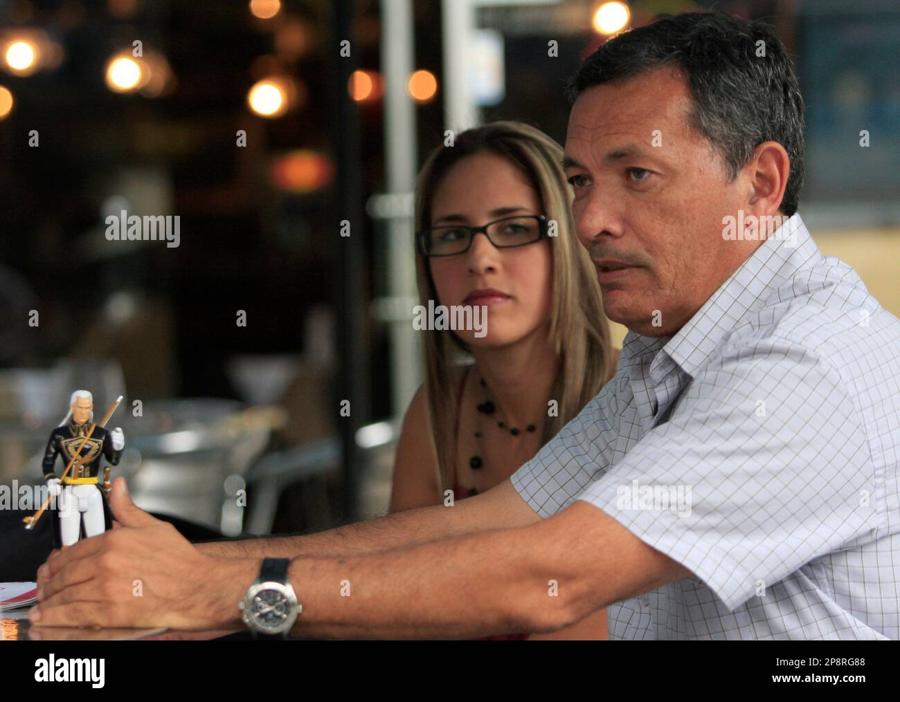 Angel Parra, right, holds an action figure in the likeness of Venezuela ...
