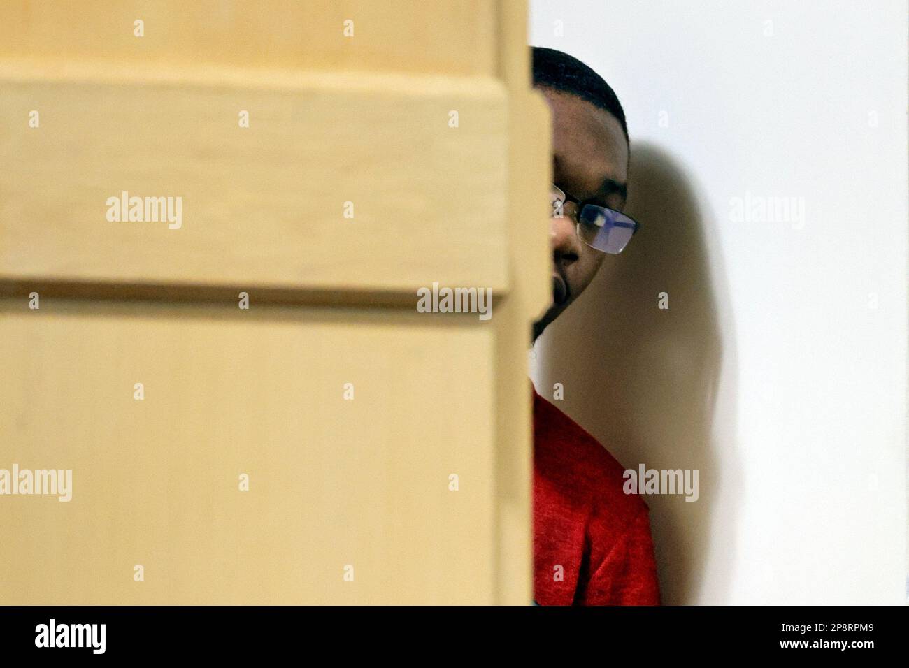 Shooting suspect Michael Boatwright peeks out from the holding area ...