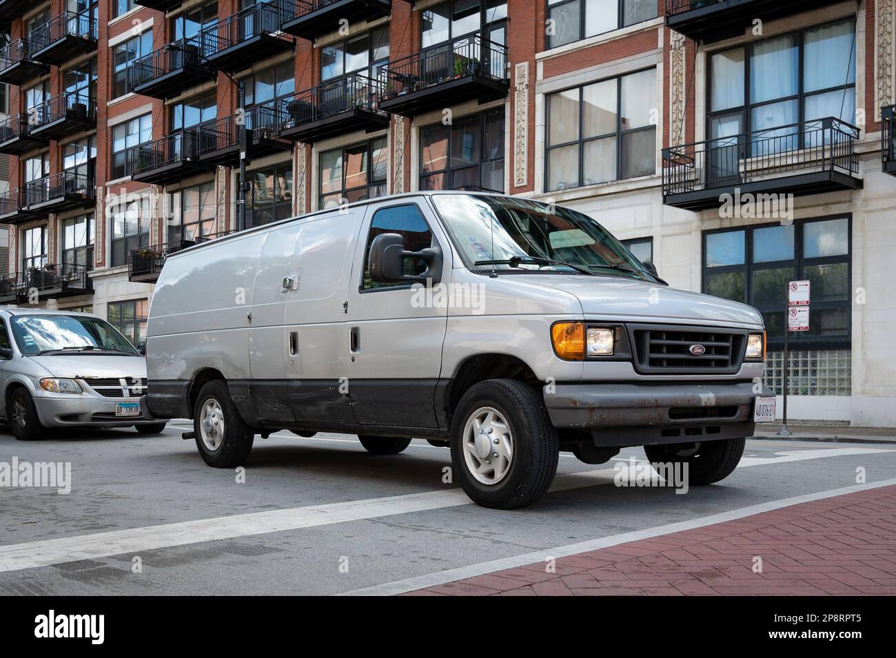 A gray van parked in a traffic jam of several smaller cars Stock Photo ...