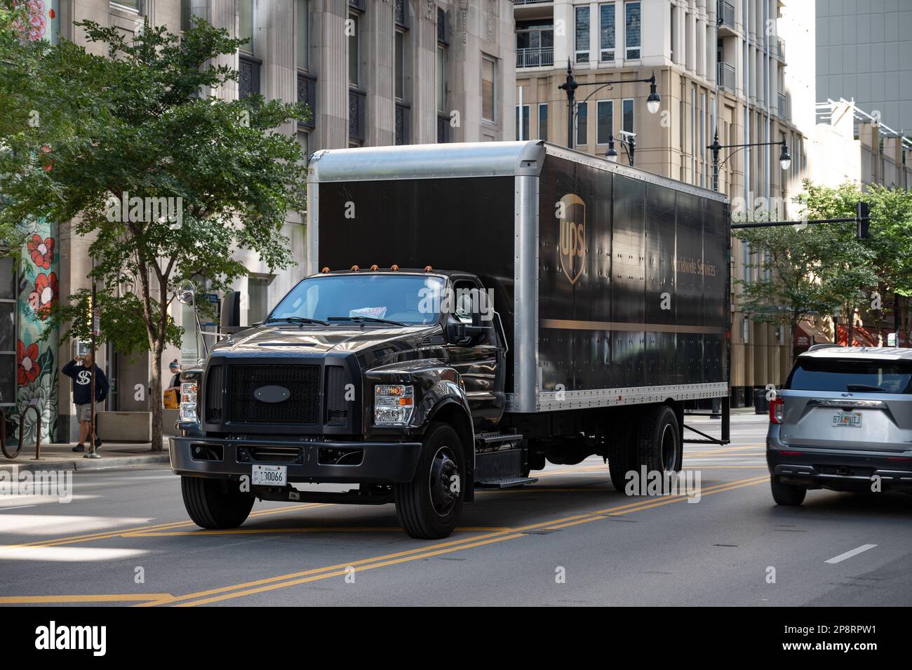 The two large vehicles driving along a city street Stock Photo - Alamy