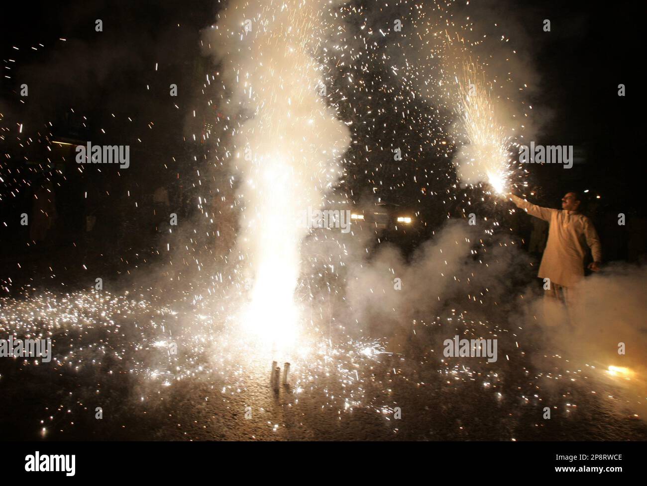 A Pakistani man holds fireworks during the celebration of Eid Milad-un ...