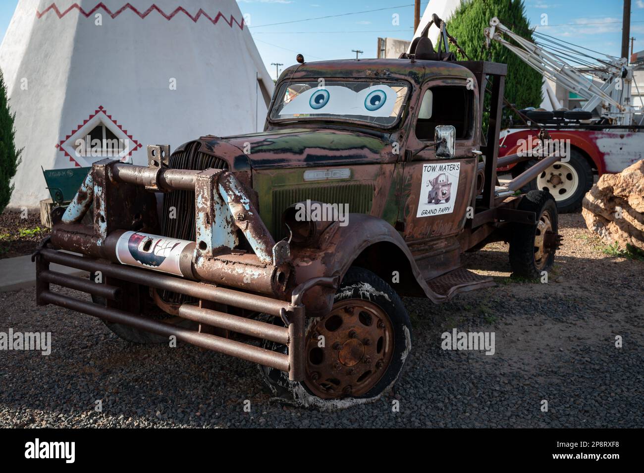 An aged car with Lightning Mcqueen eyes on it, parked in front of the ...
