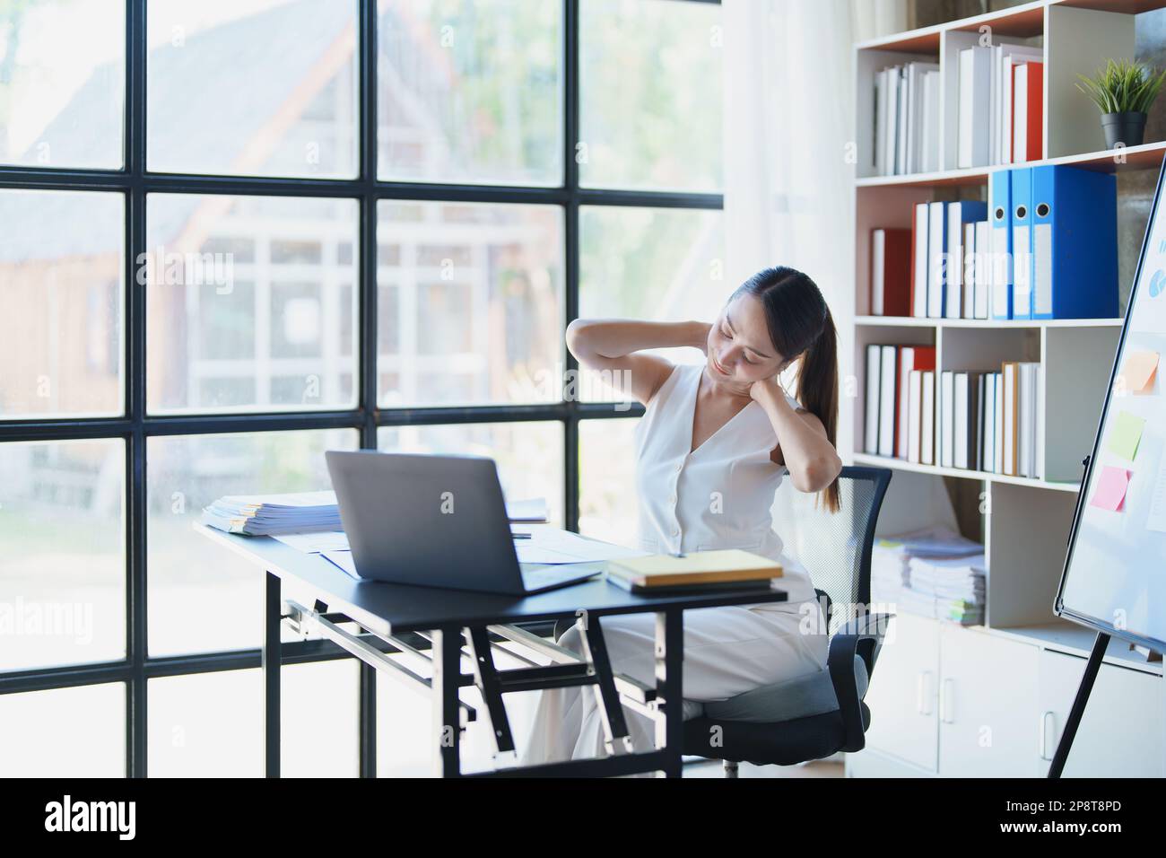 Portrait of a young Asian woman suffering from acute headache and ...