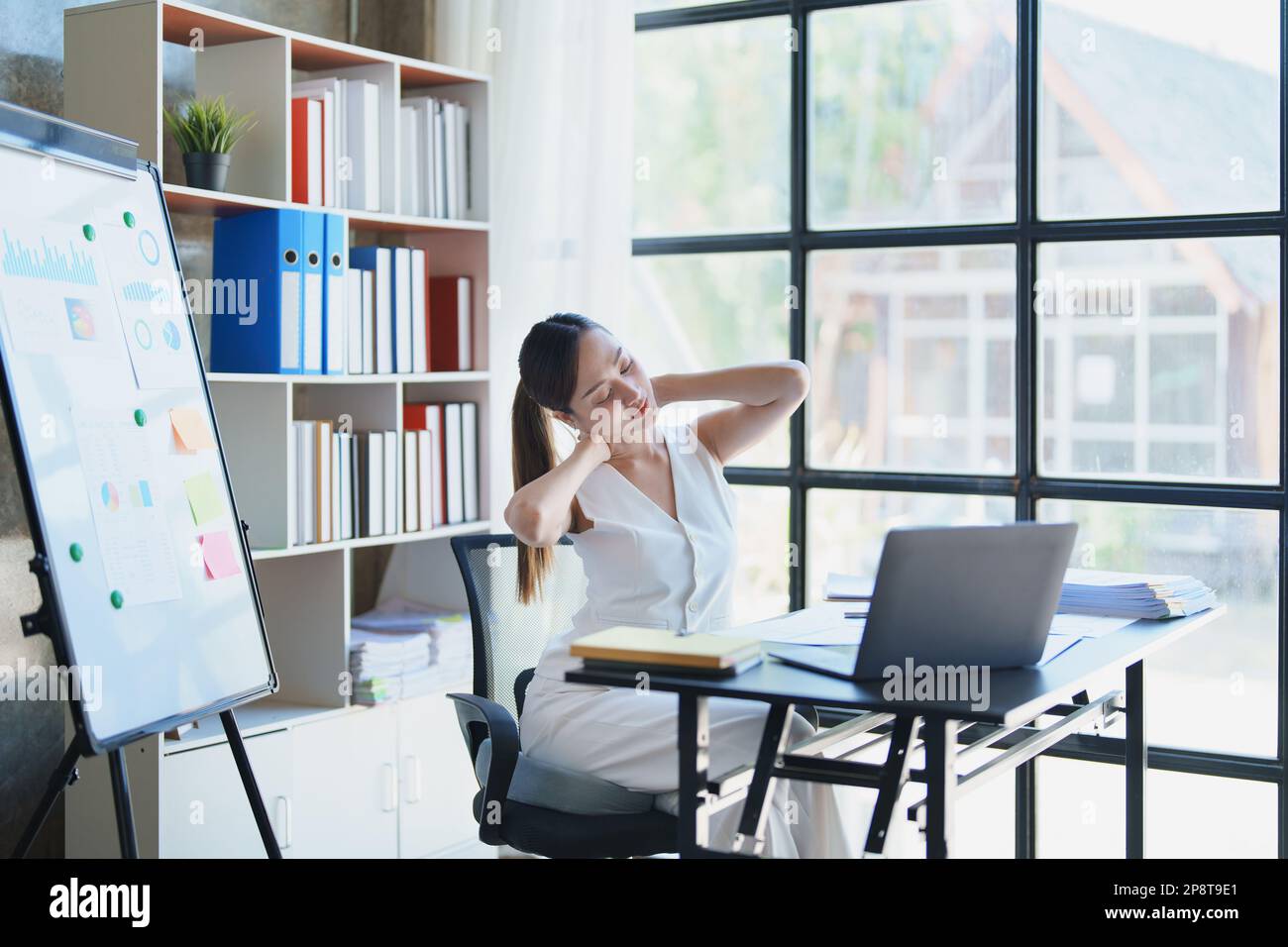 Portrait of a young Asian woman suffering from acute headache and ...