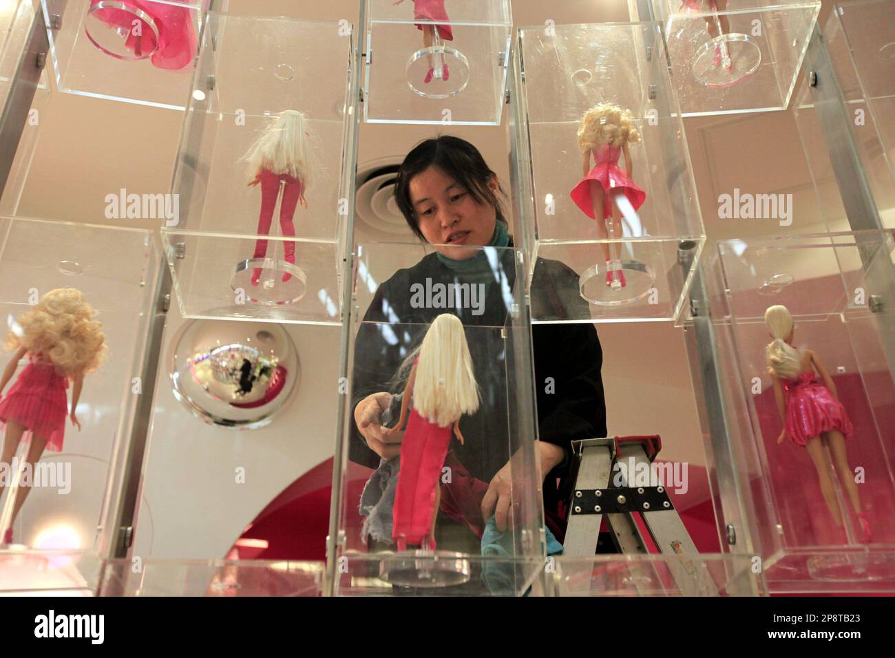 A worker cleans Barbie dolls on the display at Barbie's Shanghai ...