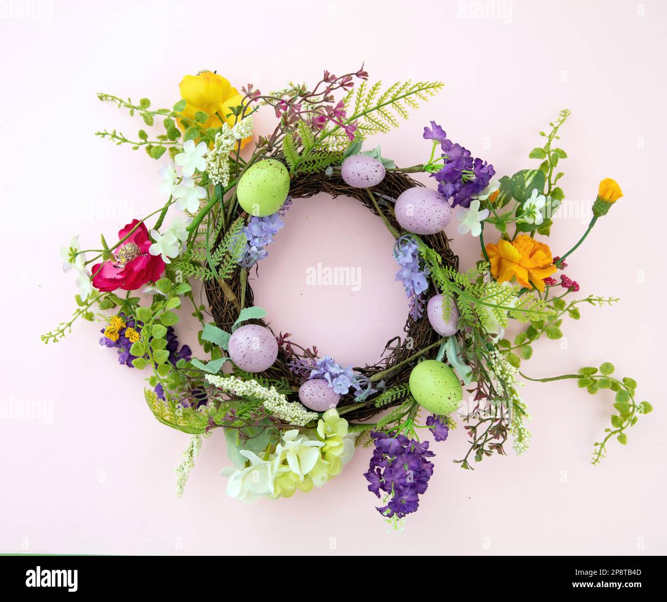 Happy Easter decoration. Easter egg and Spring flowers wreath on pink ...