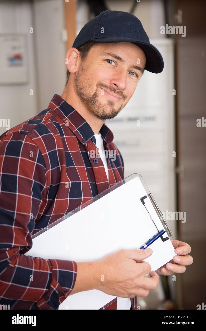 male builder writing on clipboard Stock Photo - Alamy