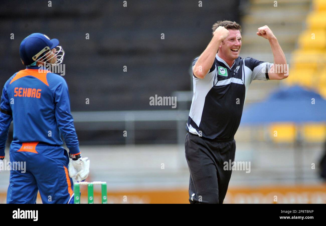 New Zealand's Ian Butler, right, celebrates the dismissal of Virender ...