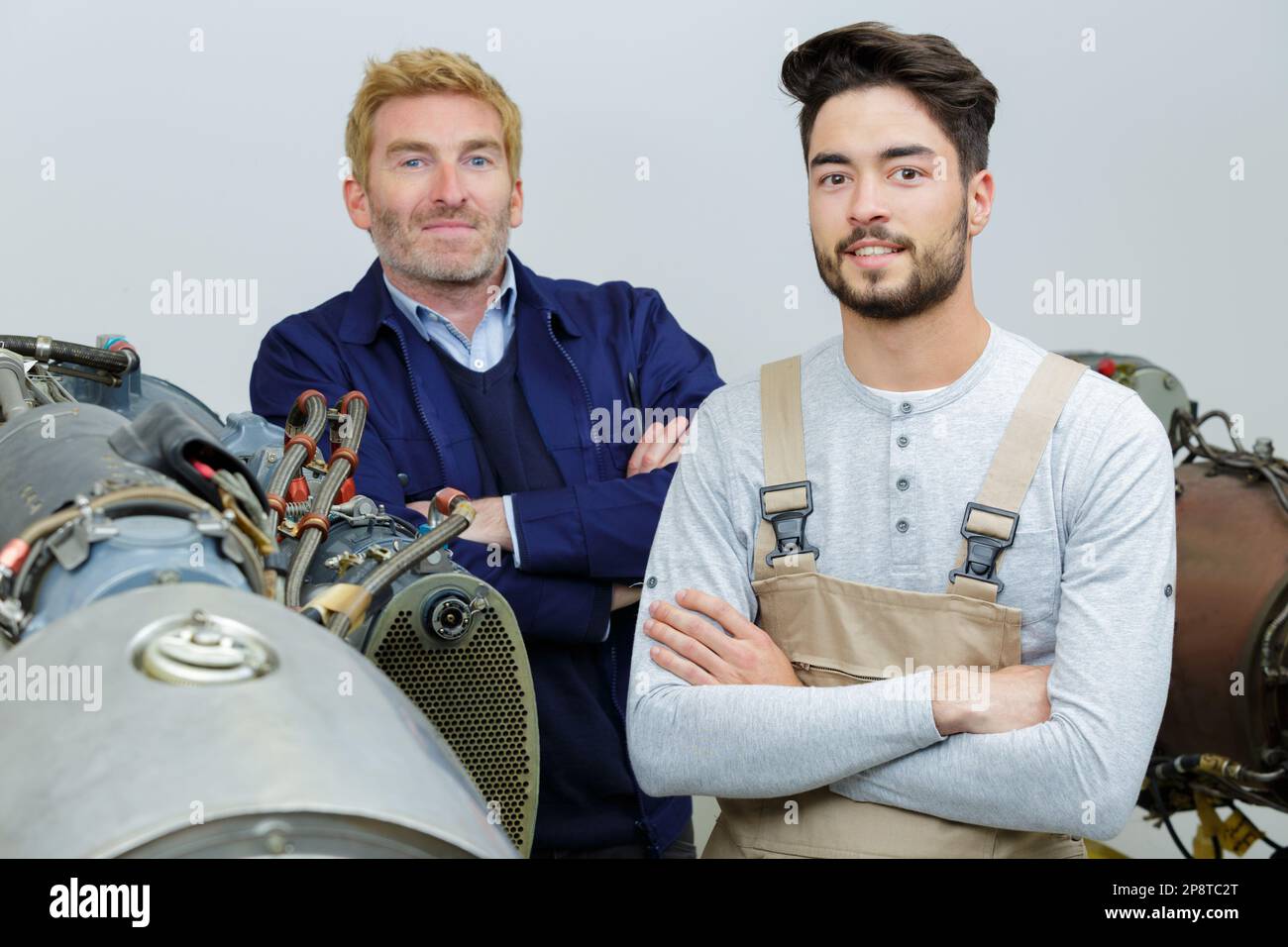 young big motor and engine mechanic posing with colleague Stock Photo ...