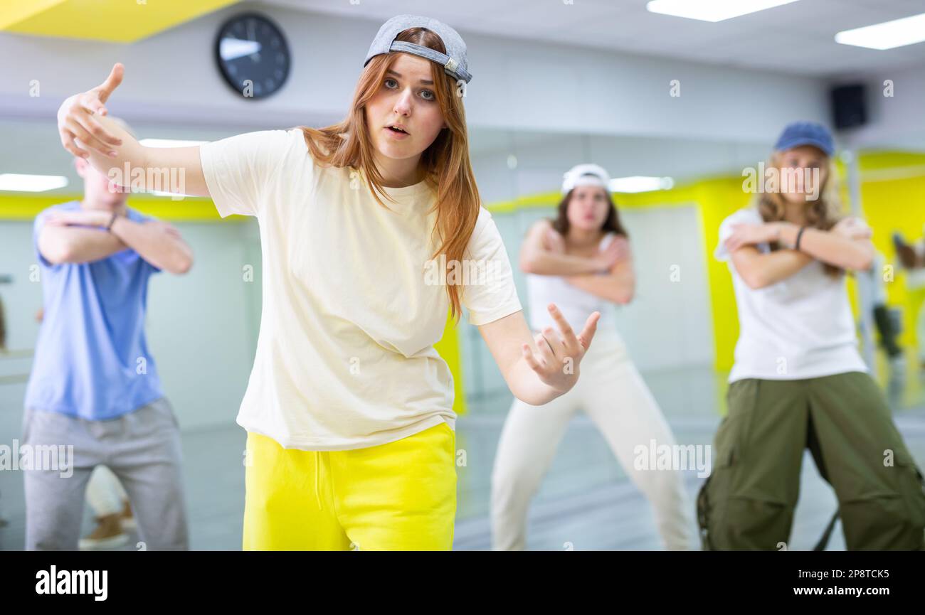 Young girl in cap training breakdance Toprock moves in dance hall Stock ...