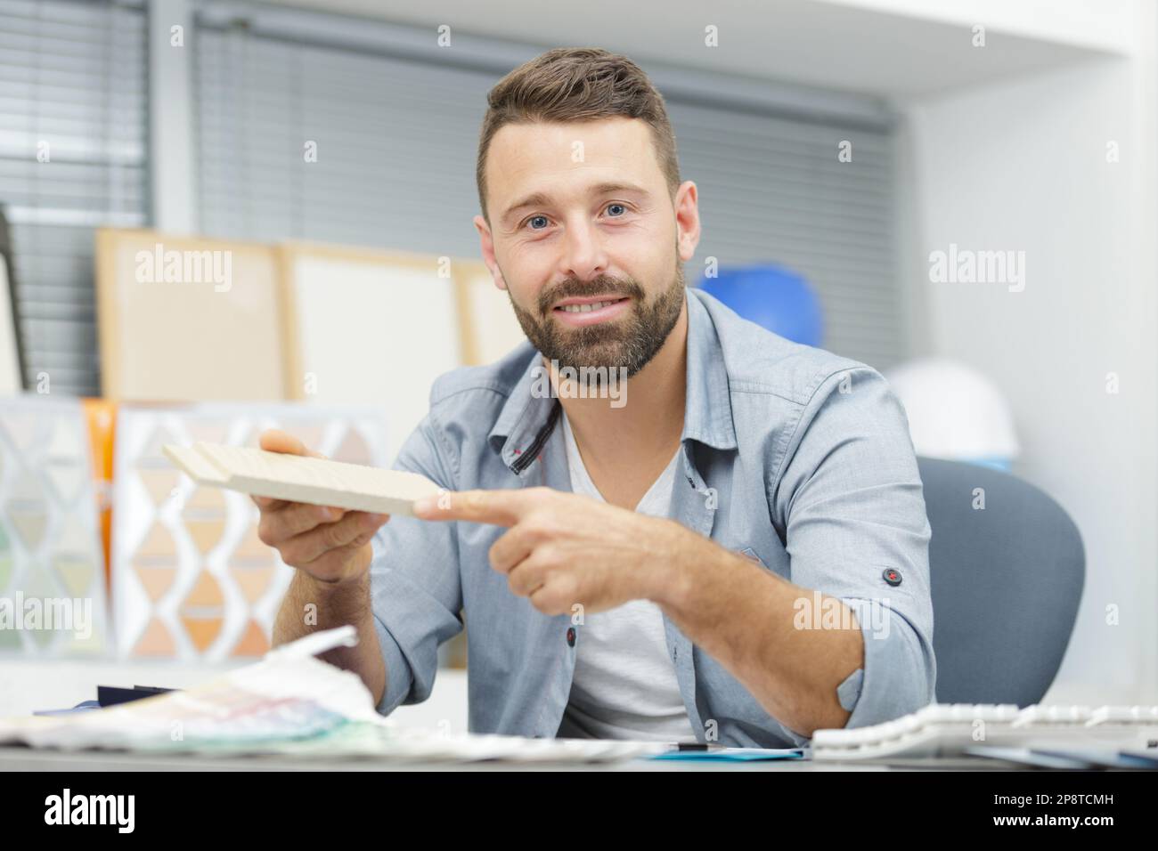 male interior designer working at desk planning color charts Stock ...