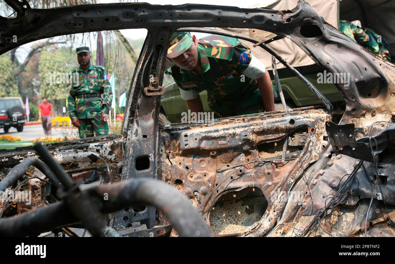 Bangladesh's army soldiers inspect a burned car at the Bangladesh ...