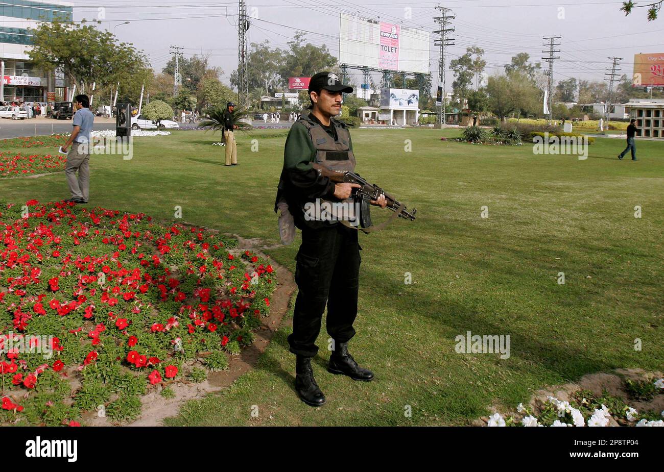 Pakistani police officers stand guard at near the shooting site in ...