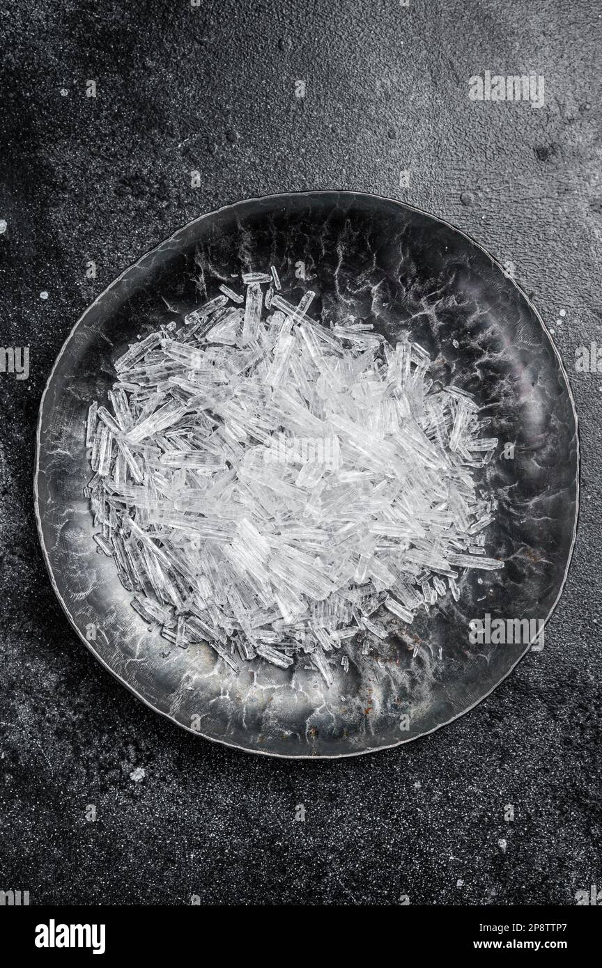 Menthol Crystals in a steel small plate. Black background. Top view ...