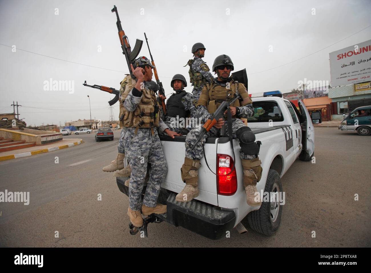 Iraqi police officers sit on a police truck during a patrol in Baghdad ...
