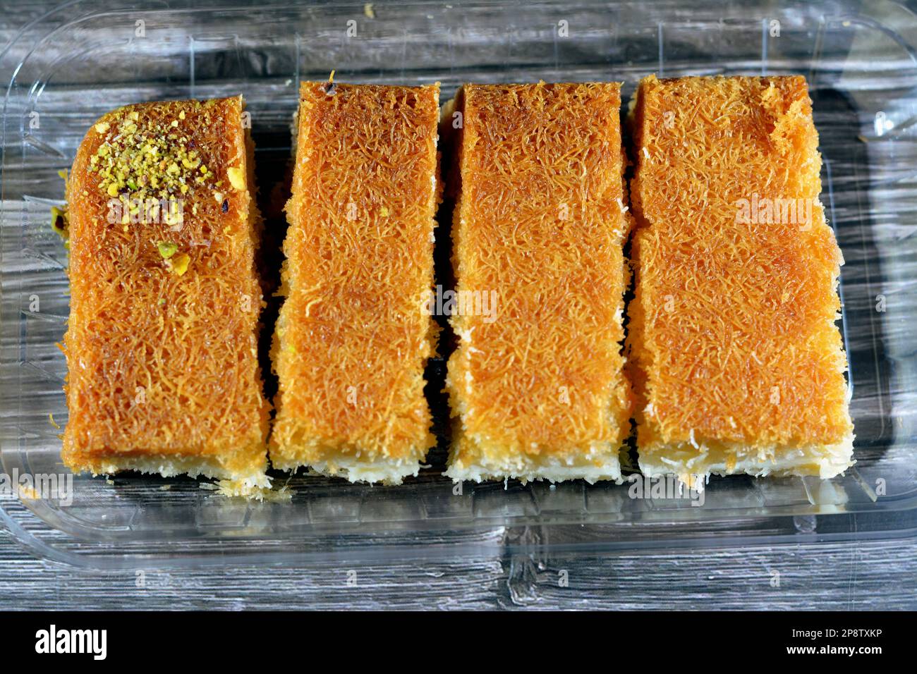 Konafa covered with nuts and stuffed with whipped cream and soaked with ...