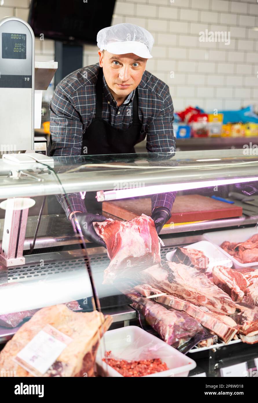 Butcher offering piece of raw beef fillet in butchery Stock Photo - Alamy