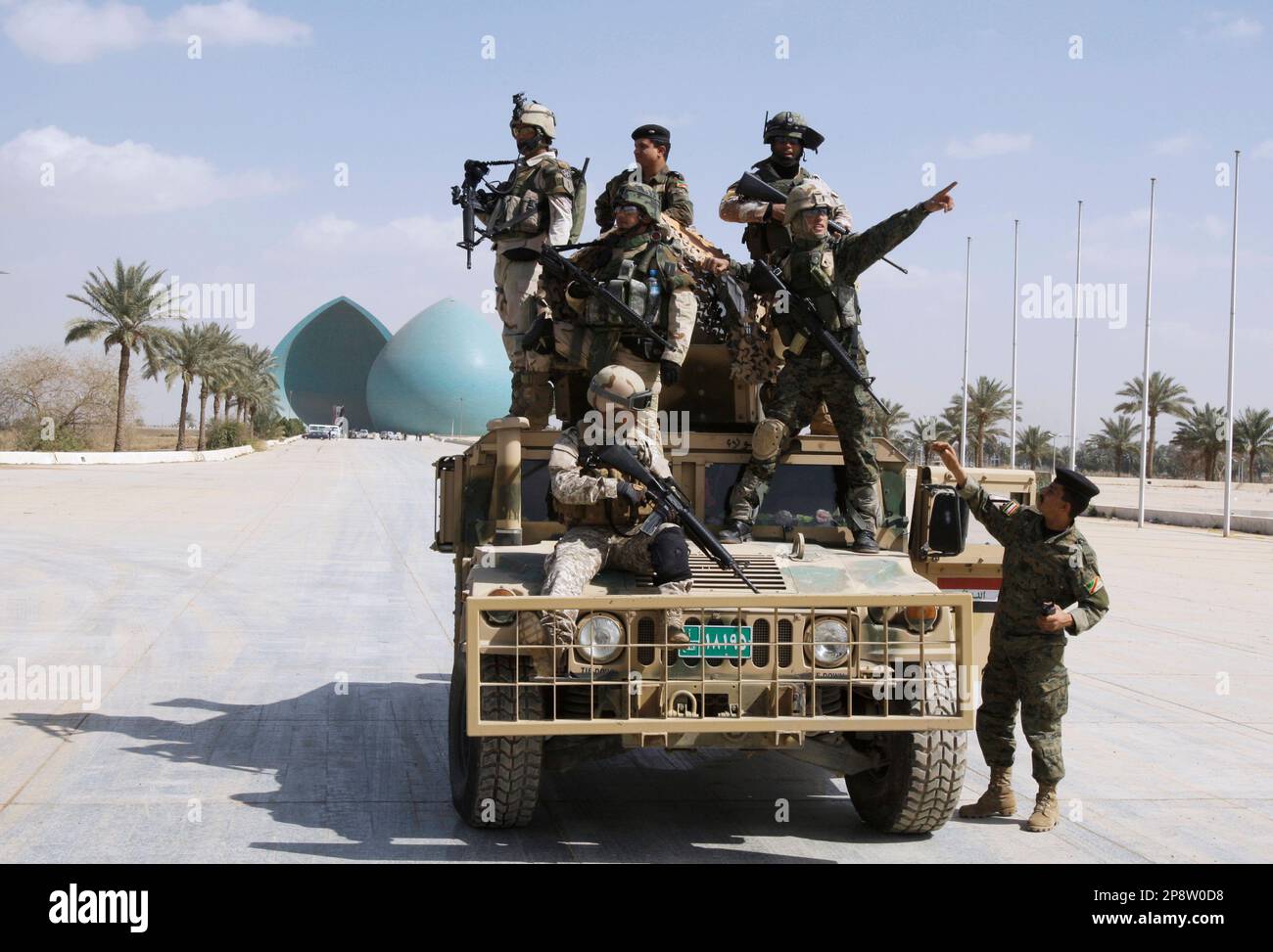 Iraqi soldiers stand on top of a Humvee in front of the Martyr monument ...