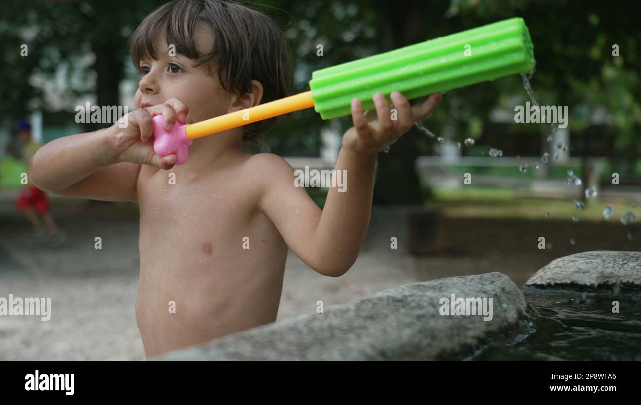 Joyful child playing with Water Gun Gun Blaster Swimming Pool Outdoor ...