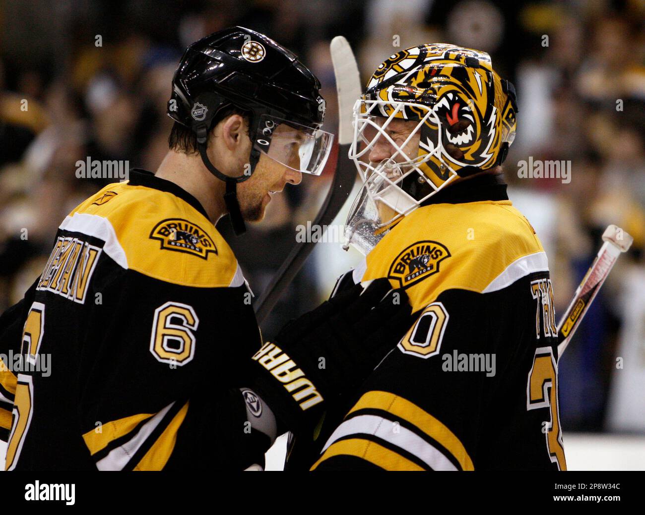 Boston Bruins goalie Tim Thomas, right, is congratulated by defenseman ...