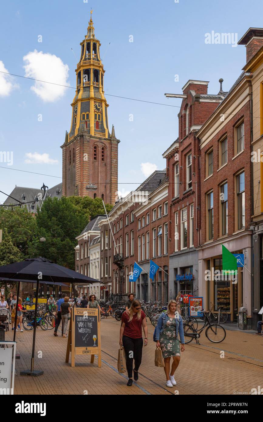 Busy shopping street with the tower of the historic Der Aa church in ...