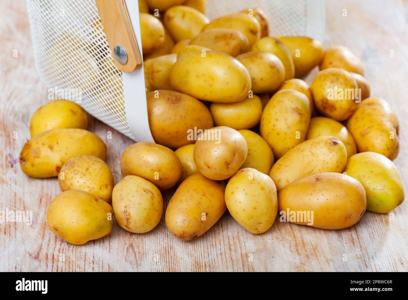 Pile of clean young potato tubers poured out of basket Stock Photo - Alamy