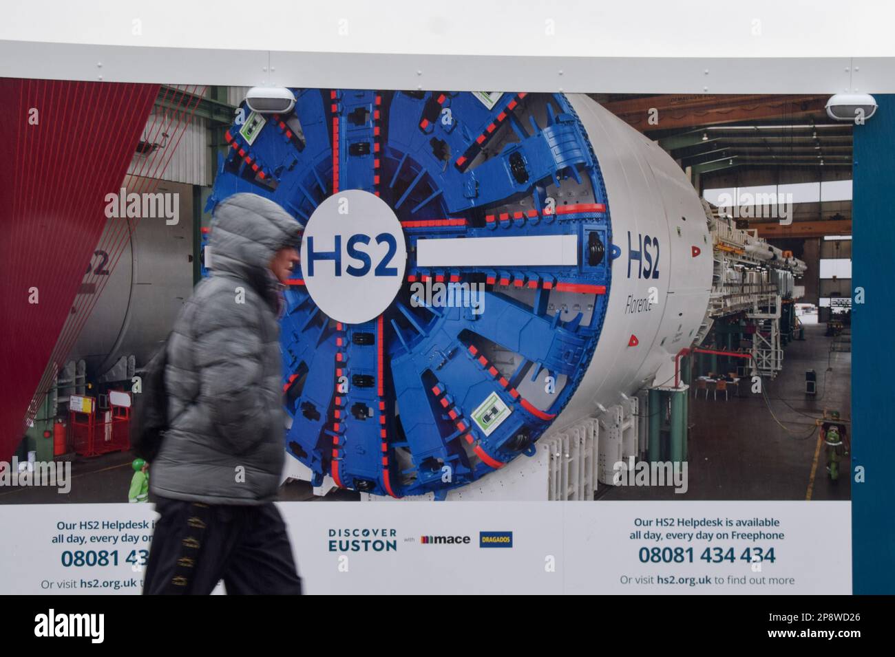 London, UK. 9th March 2023. A pedestrian walks past a sign at the HS2 ...